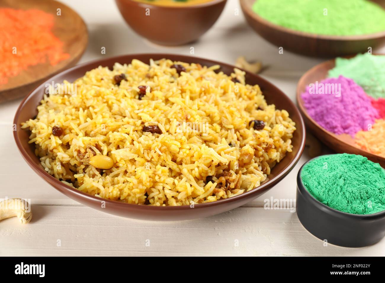 Traditional Indian food and color powders on white wooden table. Holi ...