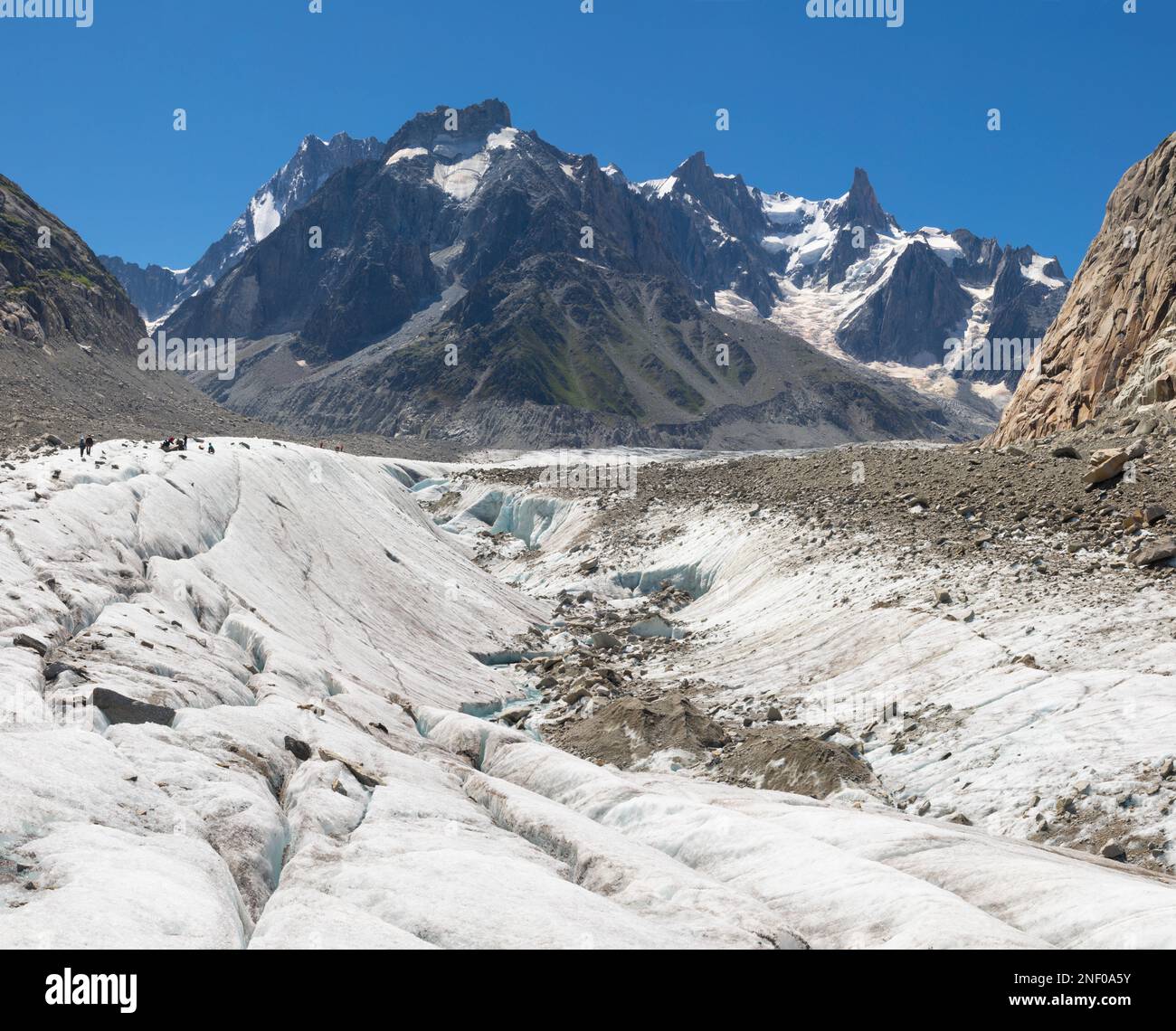 The glacial stream on the glacier Mer de Glace with the Garand Jorasses ...