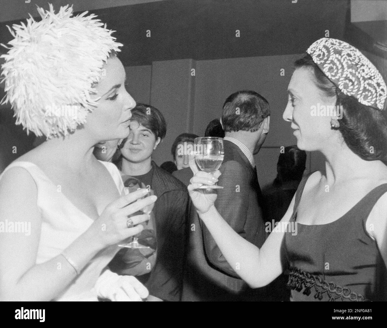 Actress Elizabeth Taylor, left, has a drink as she chats with Prima ...
