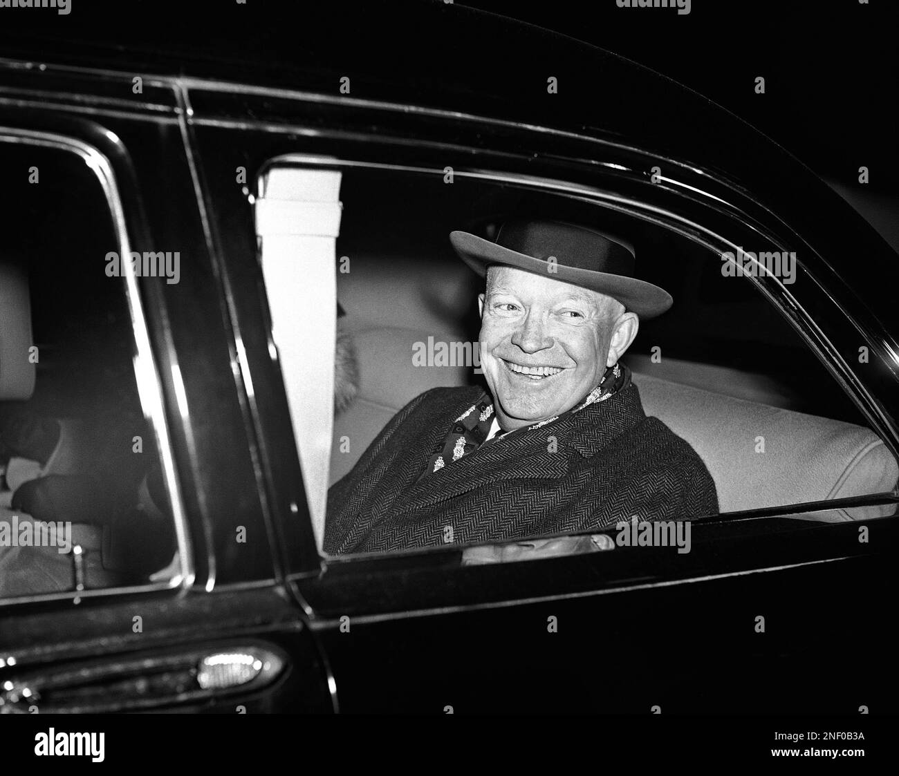 President Dwight Eisenhower flashes a big smile from his automobile ...
