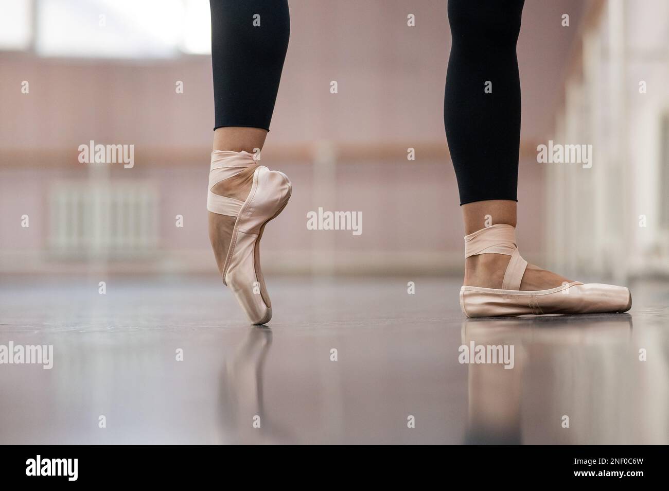 Close-up but ballerinas in pointe shoes in a dance class. The woman ...