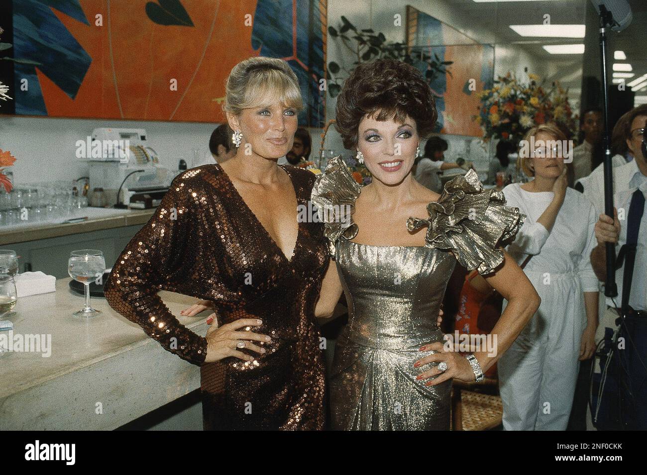 Actress Joan Collins, right, poses with Linda Evans after modeling ...
