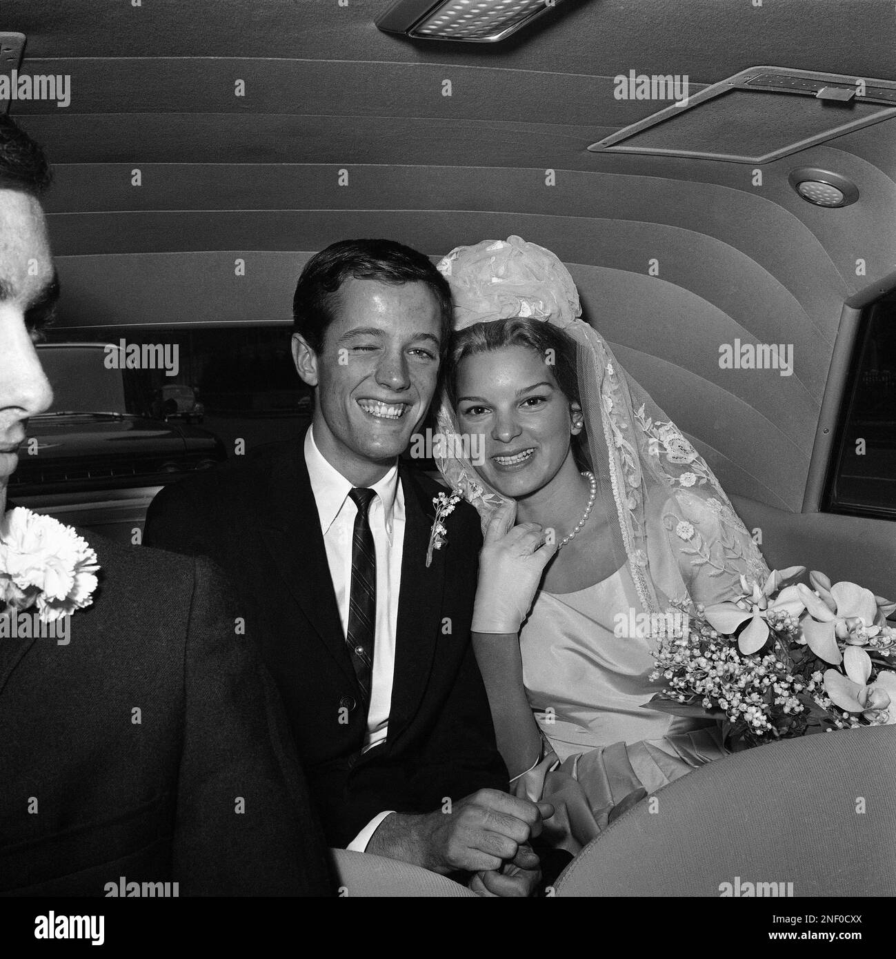 Peter Fonda, 21-year-old son of actor Henry Fonda, winks as he sits in car with his bride, Susan ...