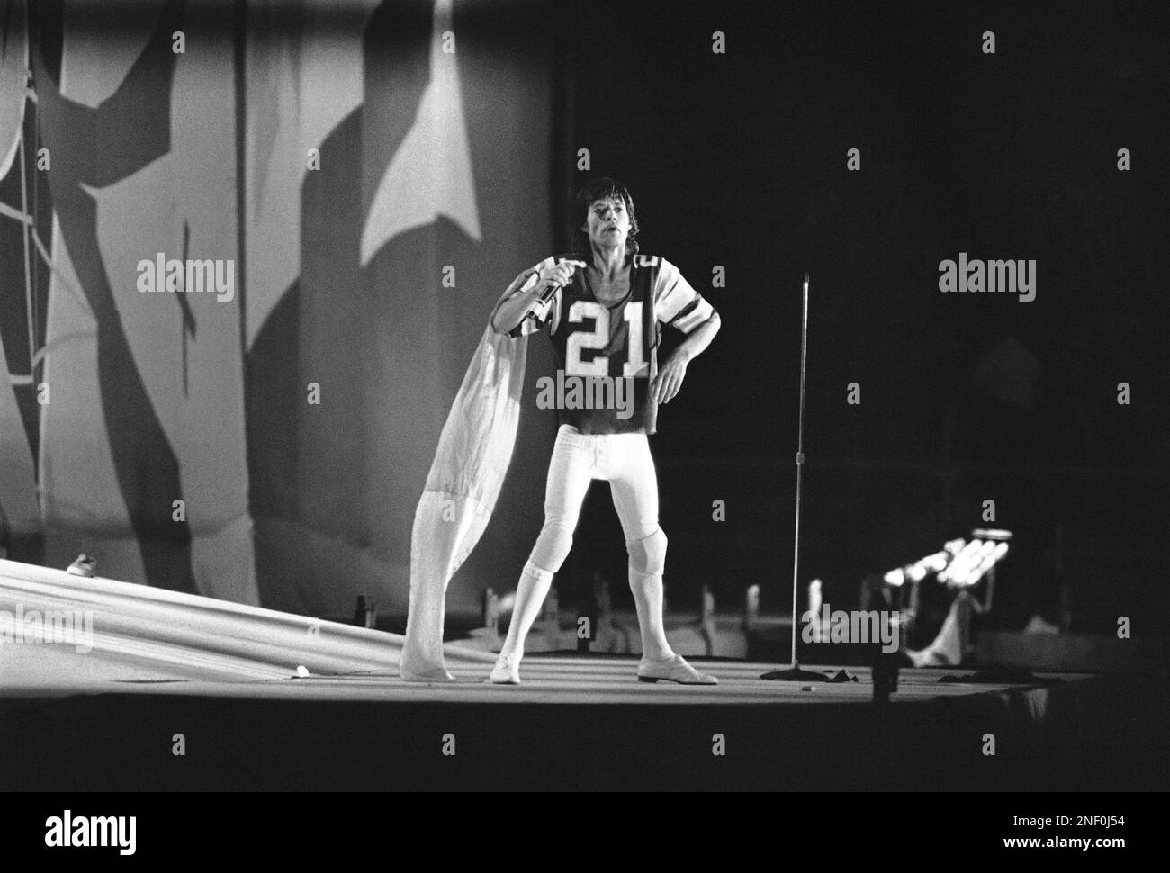 Rolling Stones singer Mick Jagger, a cape trailing behind him, belts ...