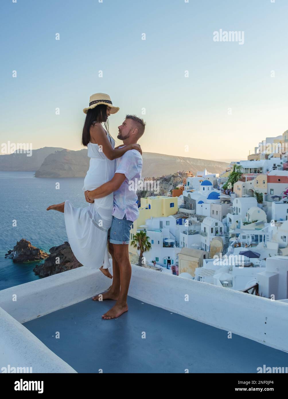 Couple hugging and kissing on a romantic vacation in Santorini Greece ...