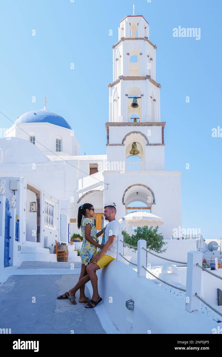 Couple hugging and kissing on a romantic vacation in Santorini Greece ...