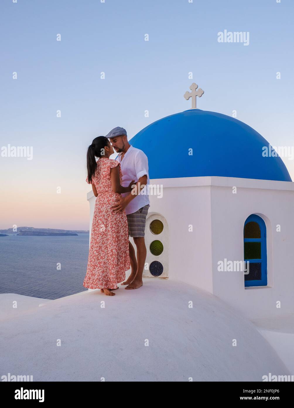 Couple hugging and kissing on a romantic vacation in Santorini Greece ...