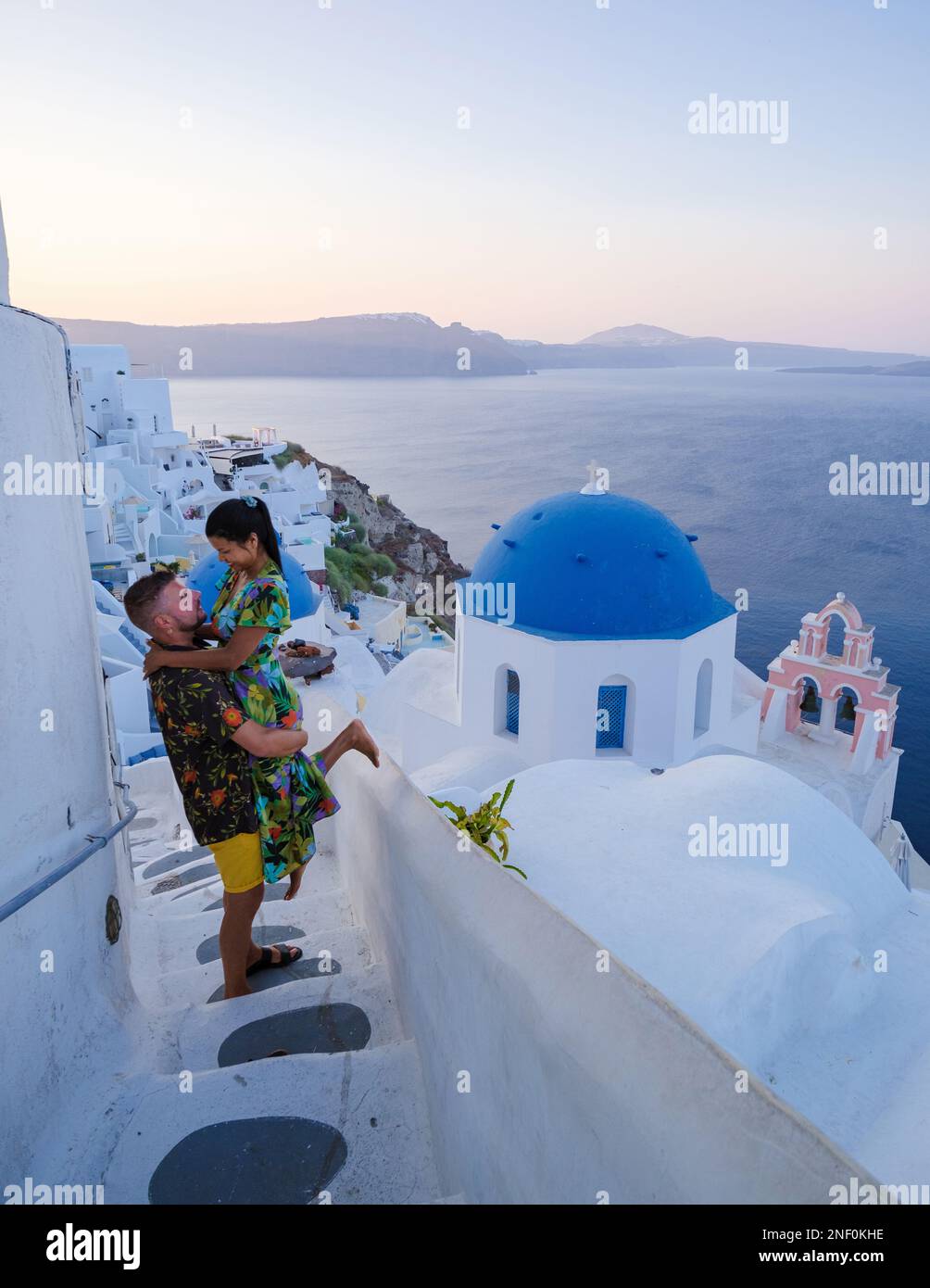 Couple hugging and kissing on a romantic vacation in Santorini Greece ...