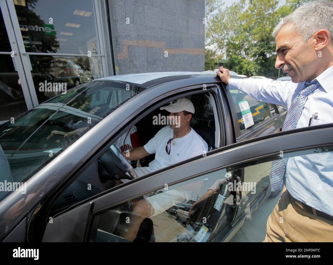 Sales consultant Mostafa Ellaida, right, shows a Toyota Corolla to ...