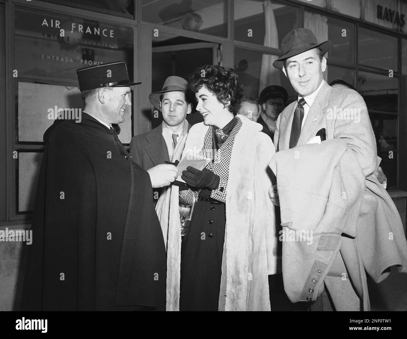 Screen actress Elizabeth Taylor smilingly gives her autograph to a ...