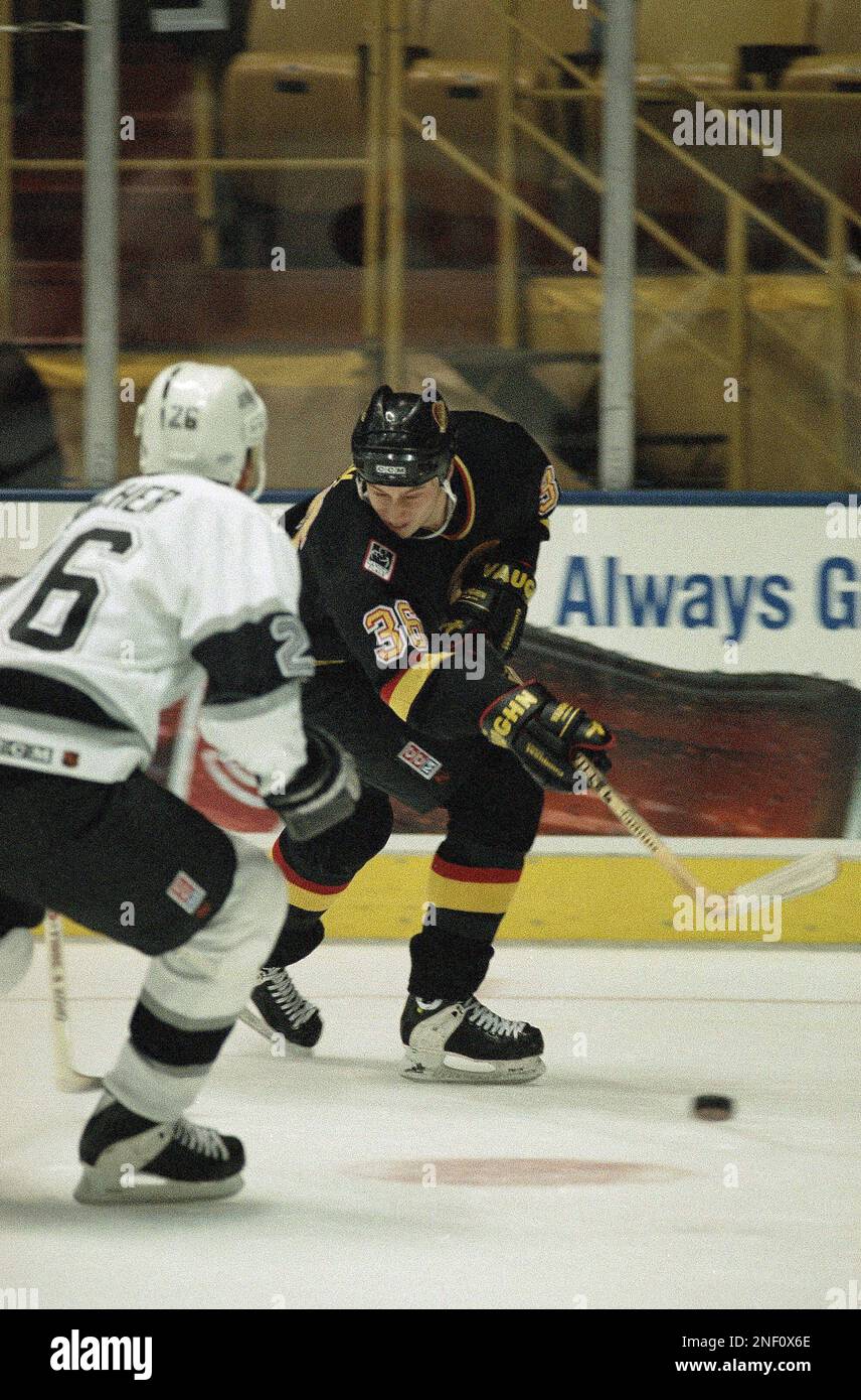 Vancouver Canucks’ Brian Loney, right, steals the puck from Los Angeles ...