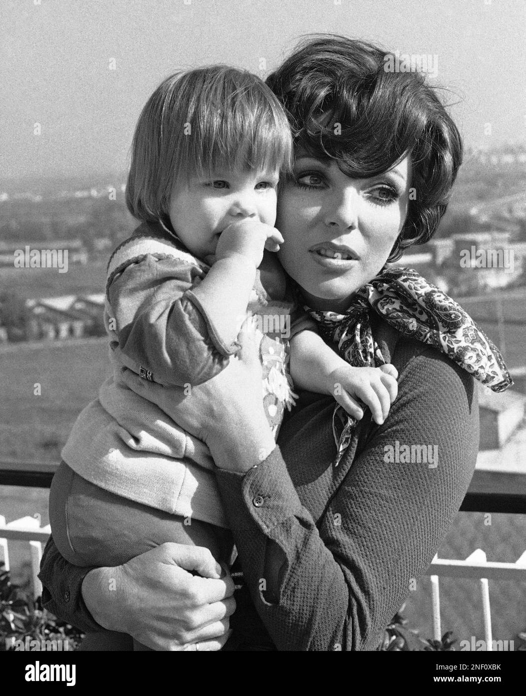 British actress Joan Collins holds her 16-month-old daughter Katyana ...