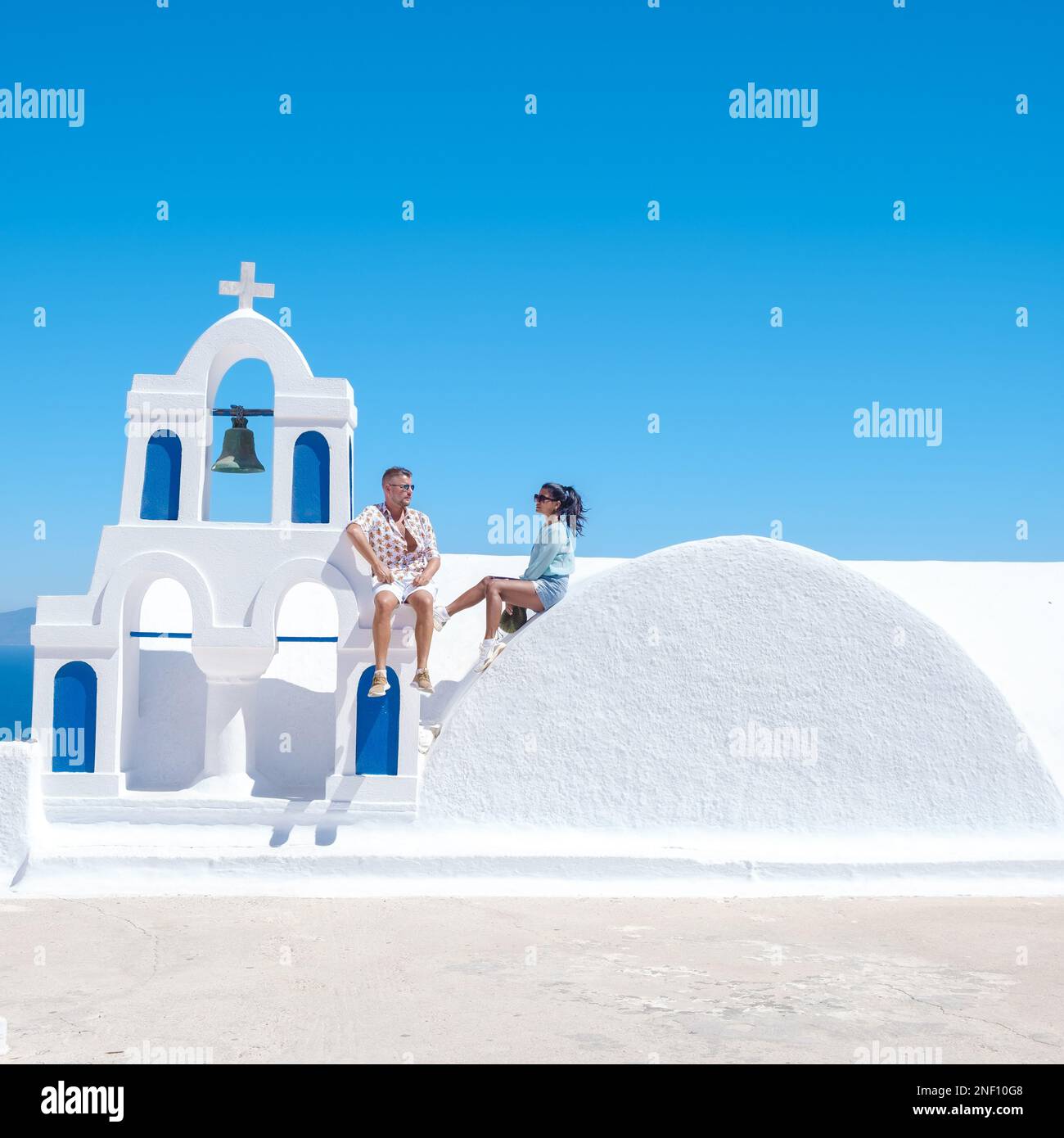 couple of men and women on vacation in Santorini Greece. young couple ...