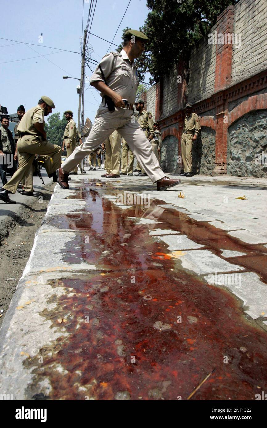 Indian Paramilitary soldiers walk near the blood stained spot of a ...