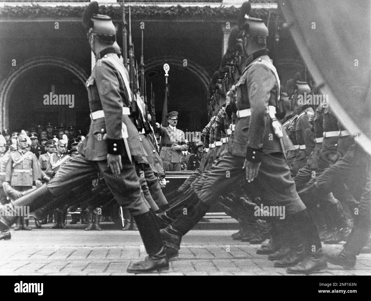 German police troops are shown parading before Adolf Hitler in front of ...