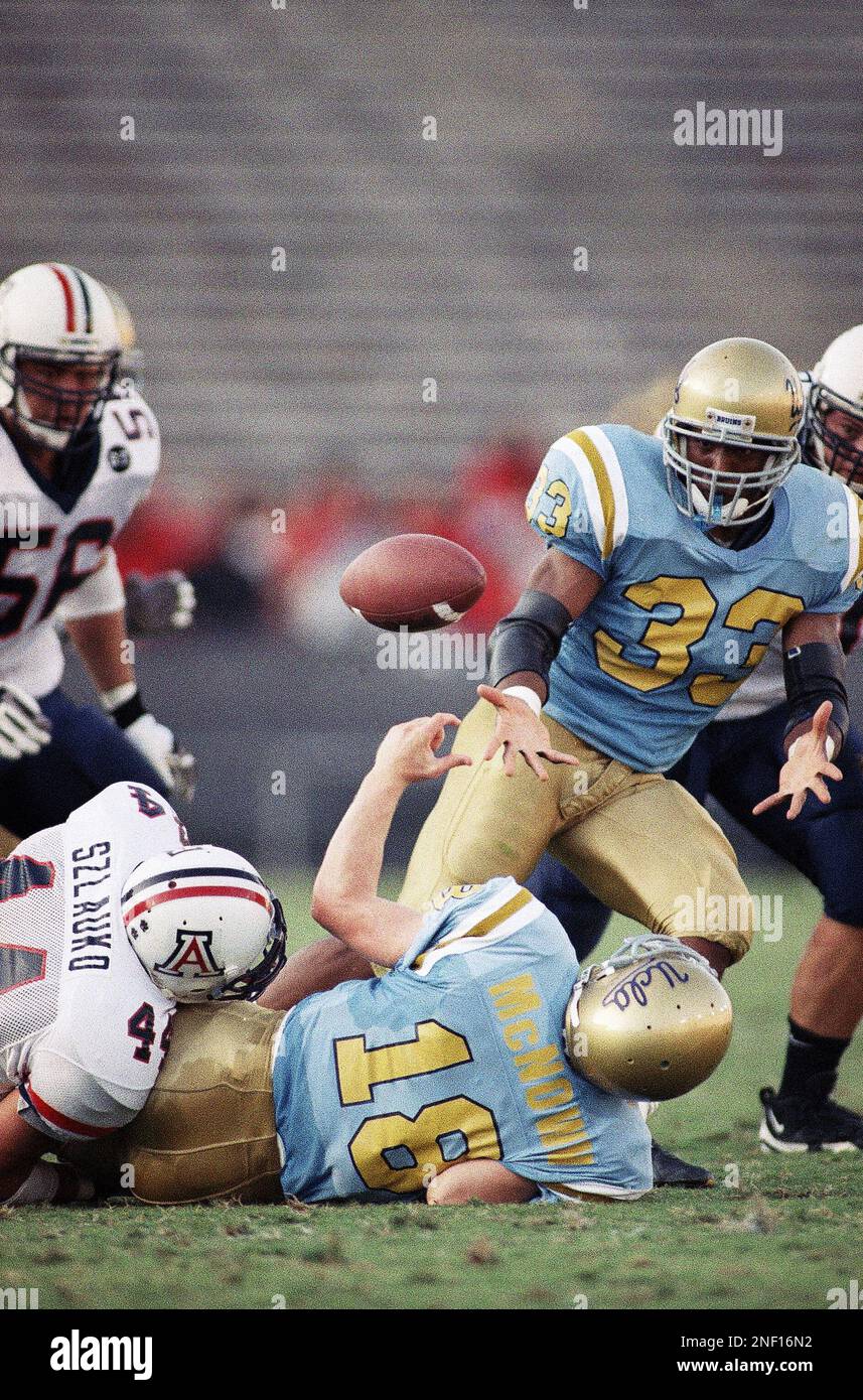 UCLA quarterback Cade McNown (18) is sacked by University of Arizona’s ...
