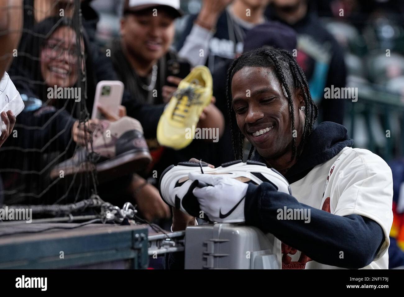 Travis Scott autographs a fan's shoe before the Cactus Jack Foundation ...