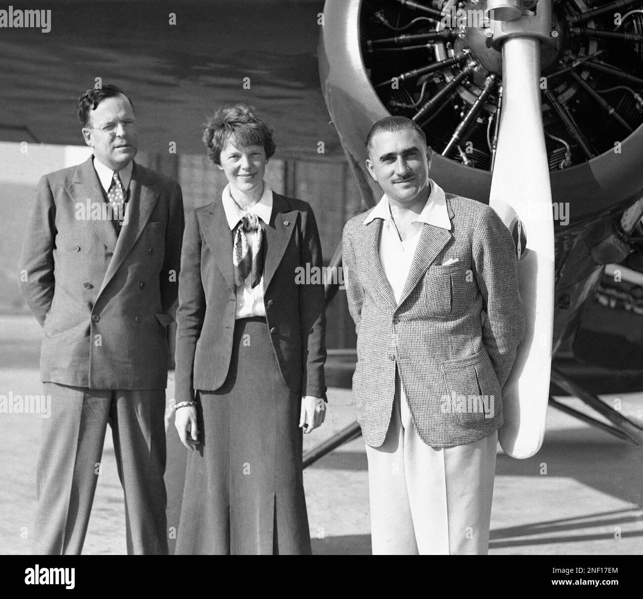 Miss Amelia Earhart, noted woman flier, center, is accompanied by her ...