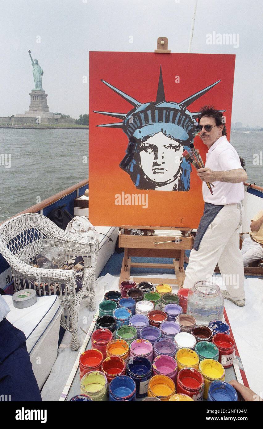 Artist Peter Max works on a painting of the Statue of Liberty aboard a ...