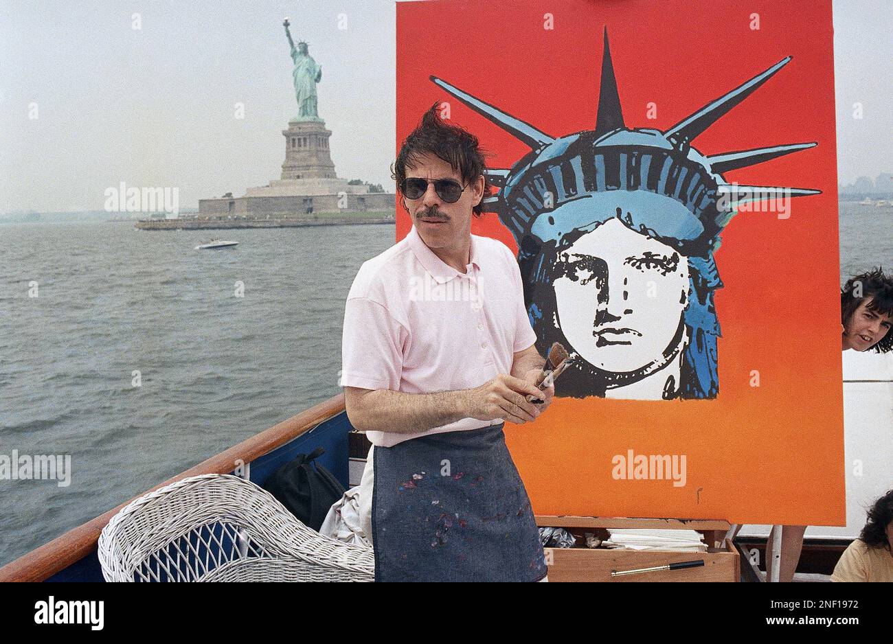 Artist Peter Max works on a painting of the Statue of Liberty aboard a ...