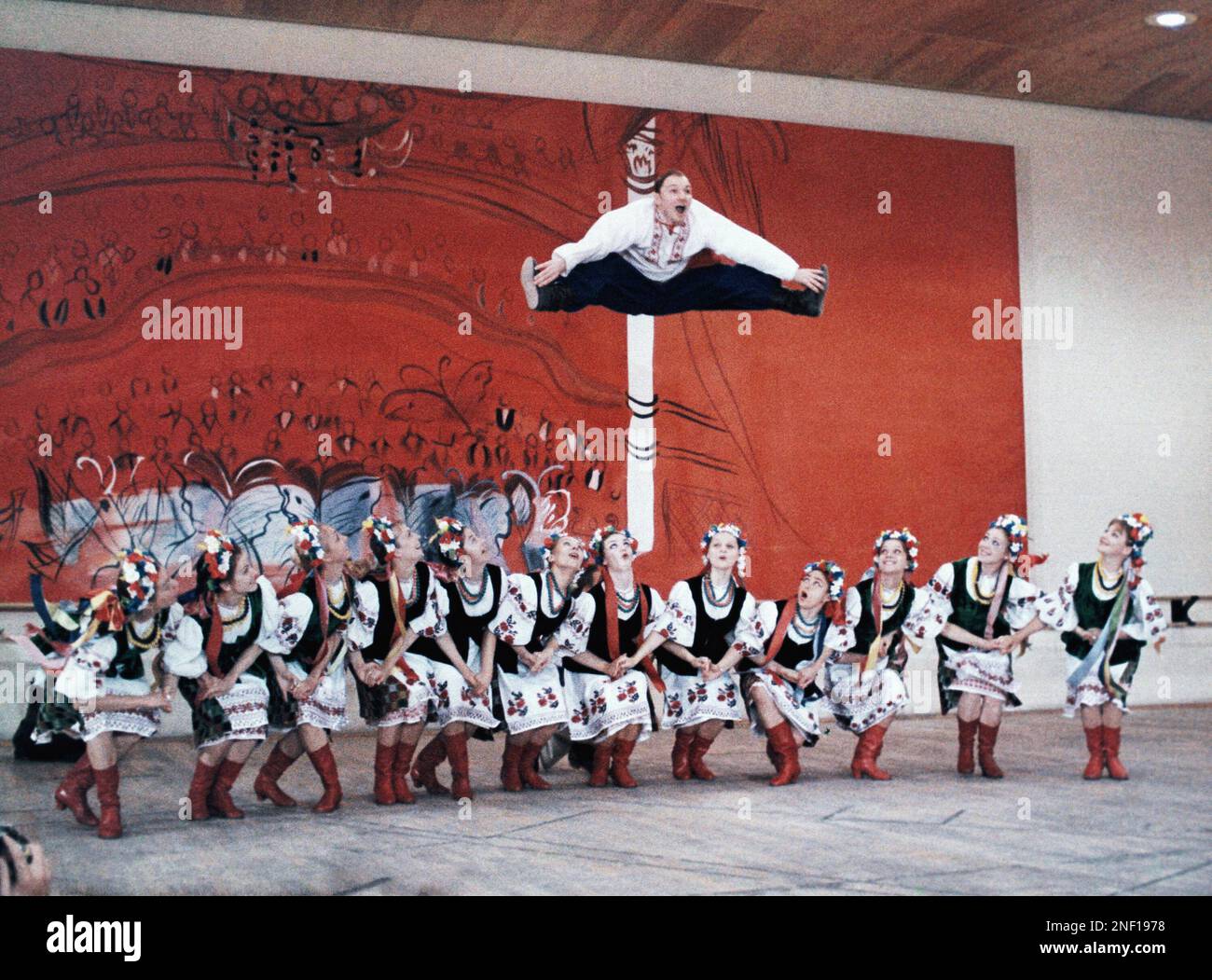 Costumed dancers of Russia’s Moiseyev Dance Company watch high-leaping ...