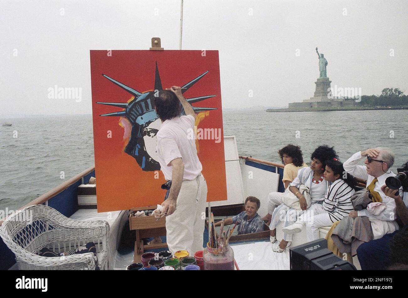 Artist Peter Max works on a painting of the Statue of Liberty aboard a ...