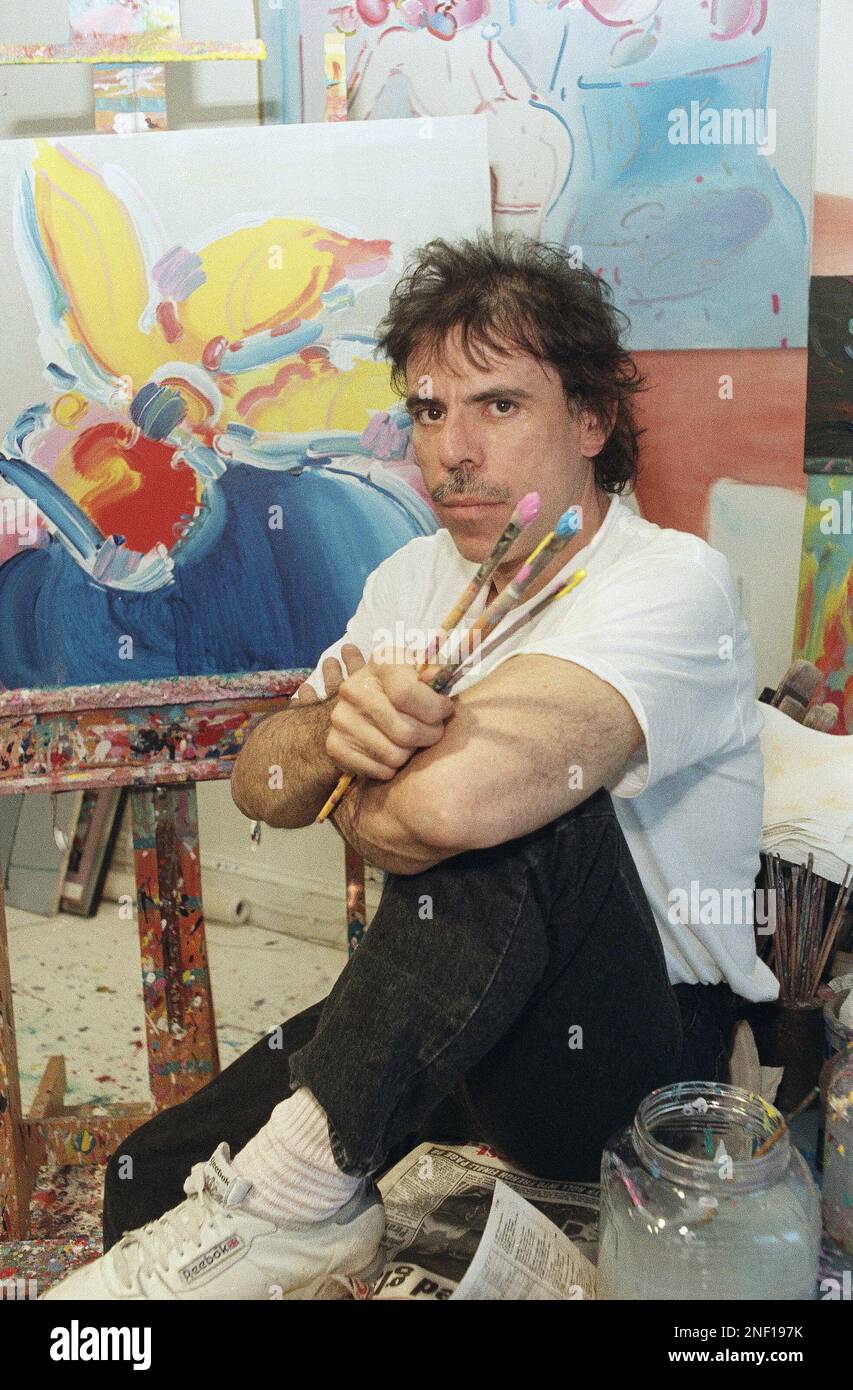 Artist Peter Max poses in front of one of his paintings in his New York ...