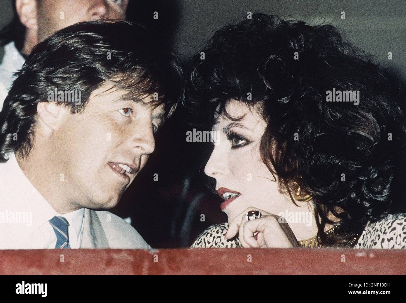 British actress Joan Collins, seated with her friend Bill Wiggins at ...