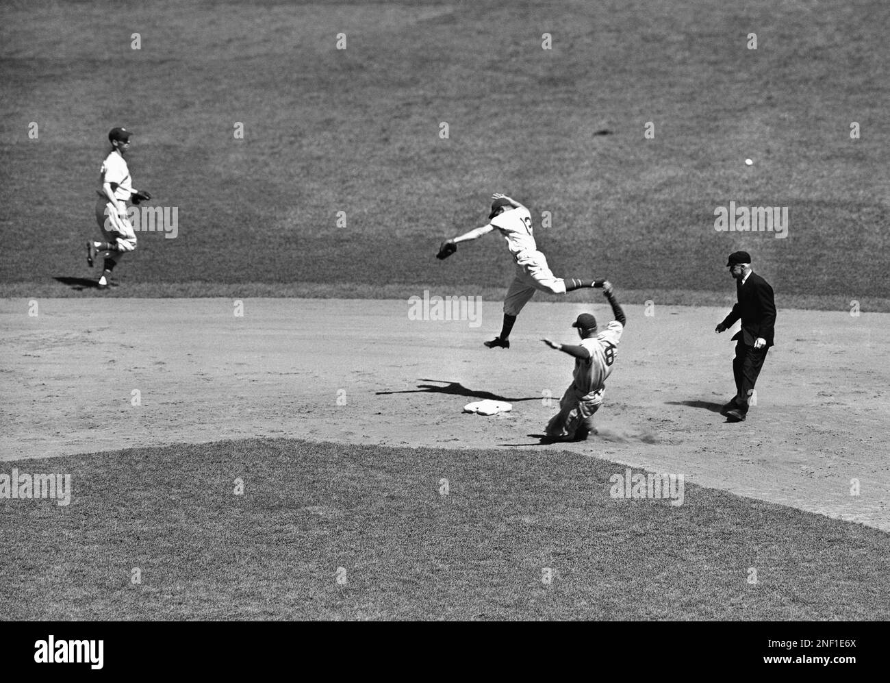 Bob Elliott, Pittsburgh Pirates third baseman, starts slide into second ...