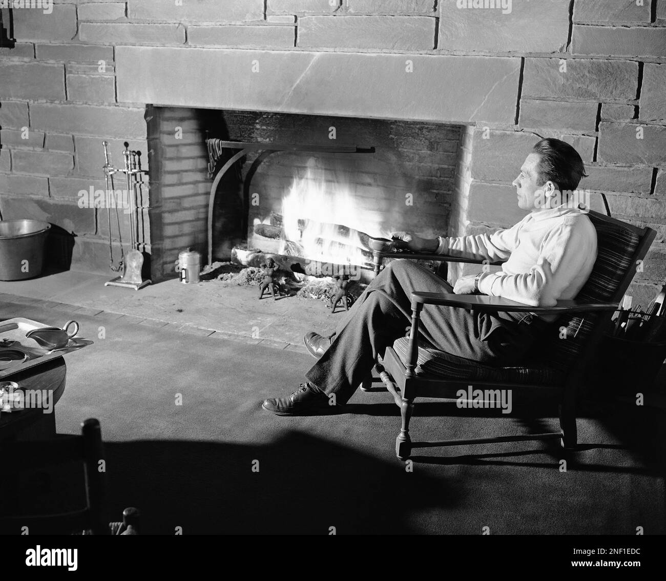 Sculptor Harvey Fite relaxes in front of the great stone fireplace of ...