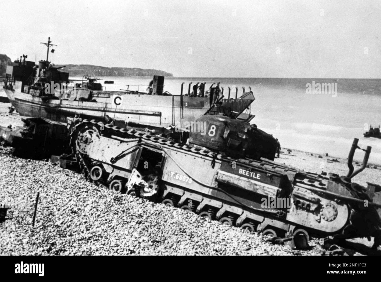 With a stranded tank landing craft in the background, a British tank ...