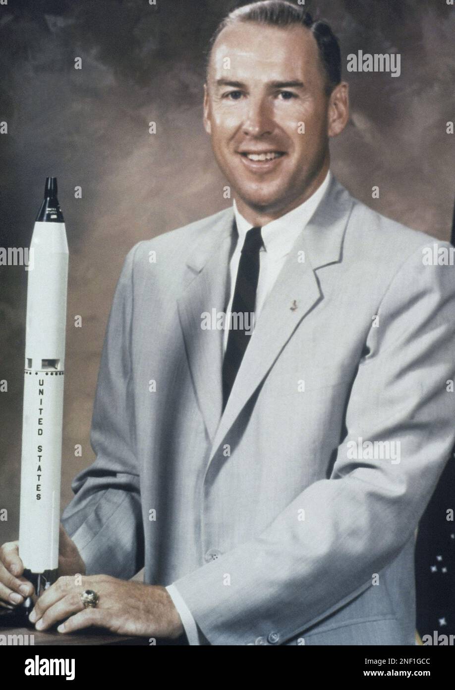 Astronaut James Lovell of Apollo 13 commander, holds a model of Saturn ...