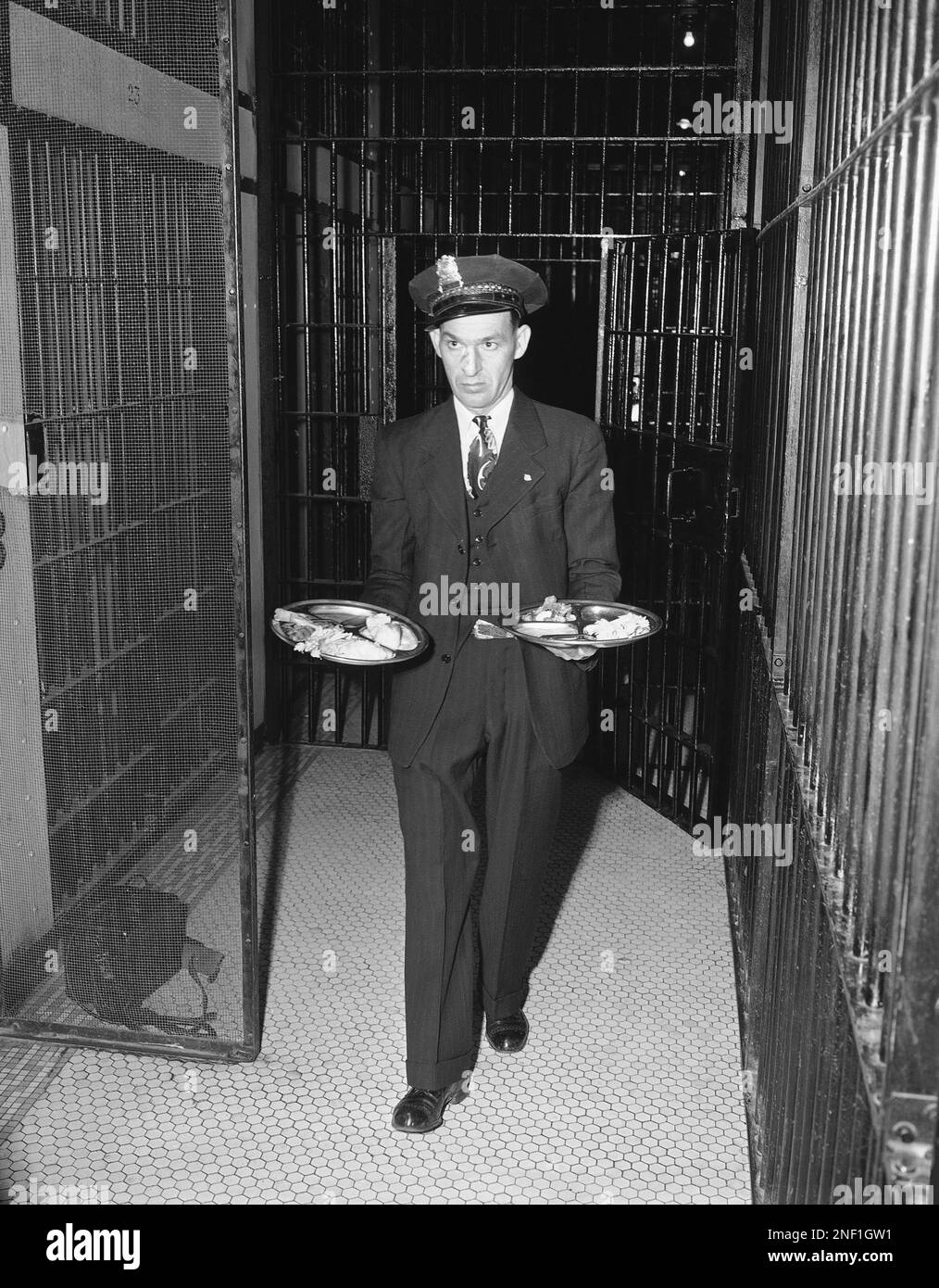 Prison guard Kenneth Hoskins carries away the trays of Carl Austin Hall ...