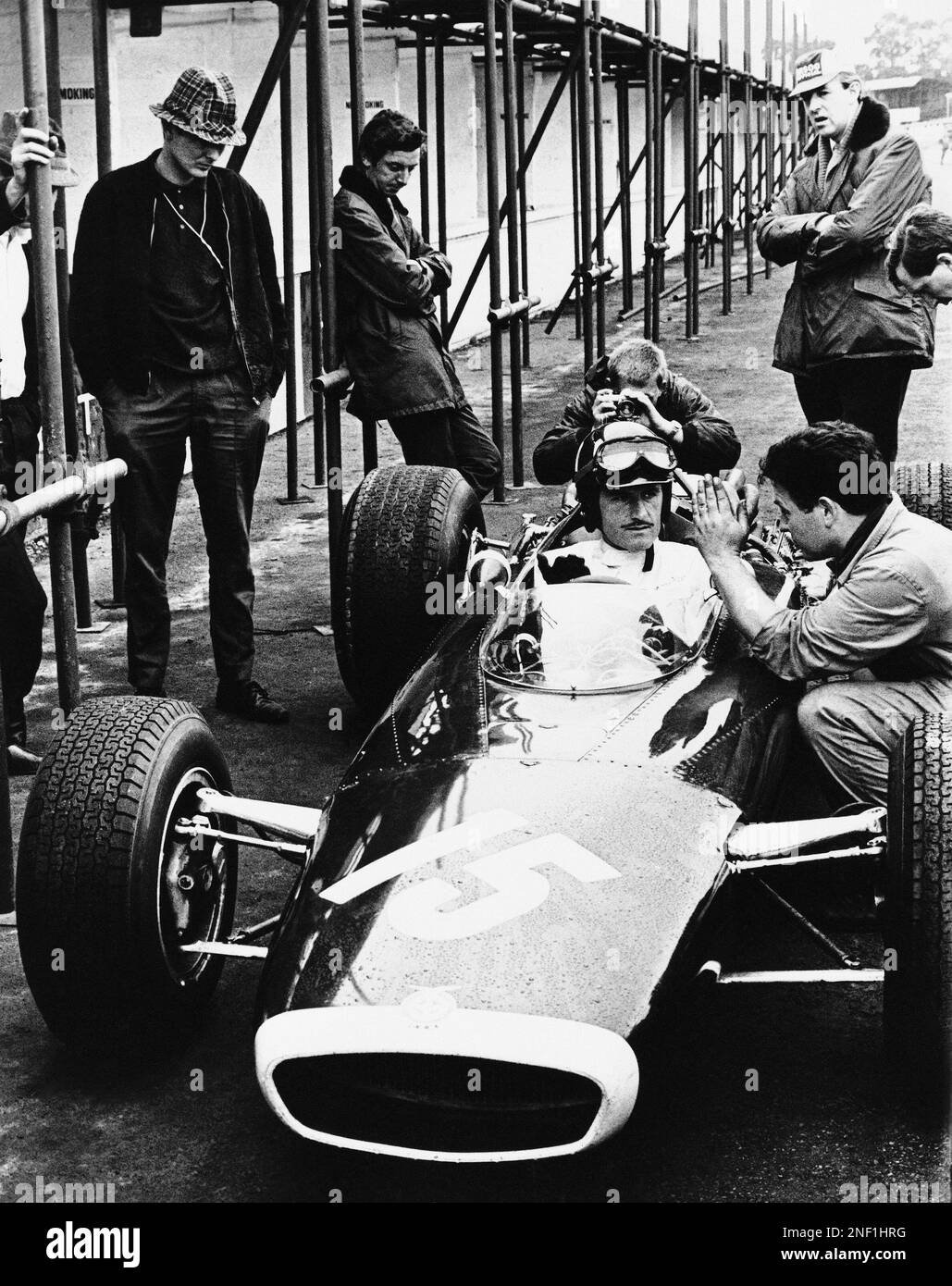 Motor racing champion, Graham Hill, is pictured in the cockpit of the ...