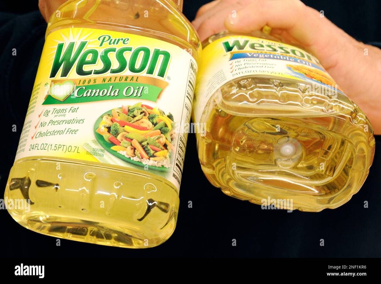 A customer holds up bottles of Wesson Oil at a grocery store, Friday ...