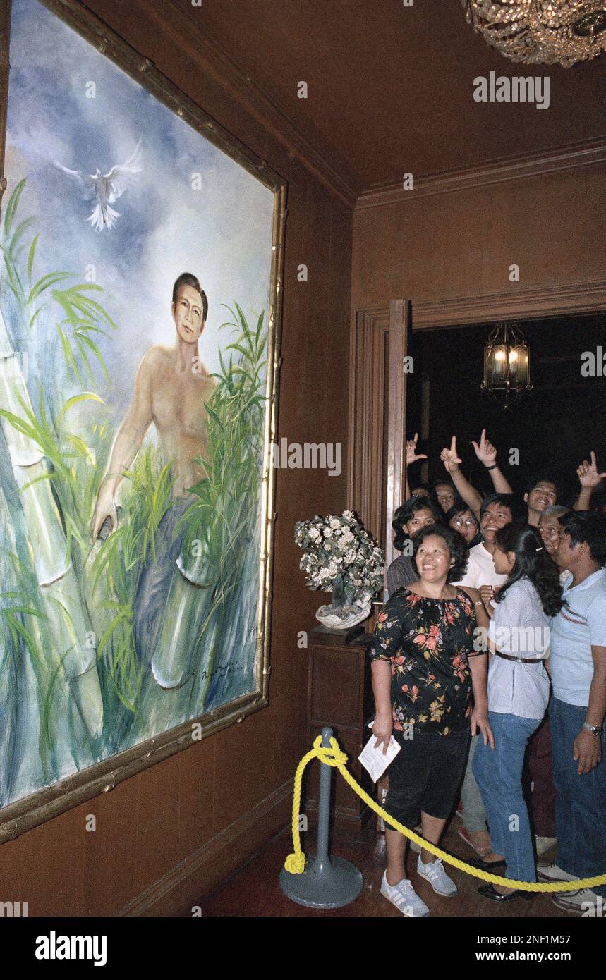 Residents view a huge painting deposed of President Ferdinand Marcos ...