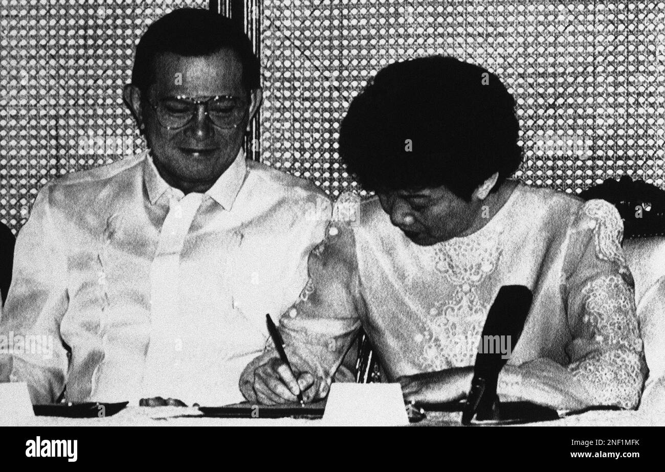 Philippines President Corazon Aquino signs the new constitution as Vice ...