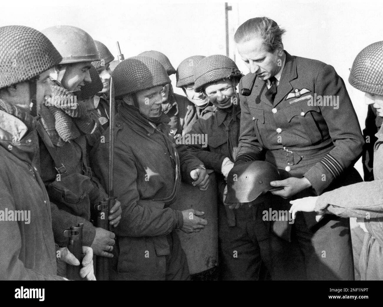 Wing commander Percy Pickard (right) examines a German military helmet ...