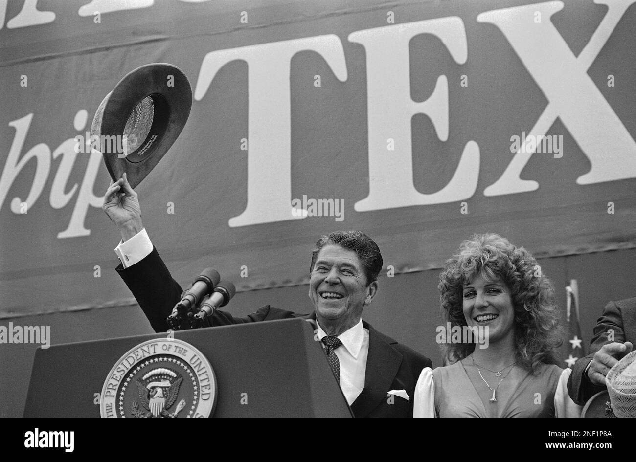 President Ronald Reagan waves his Texas straw hat given to him by Houston Oilers Cheerleader ...