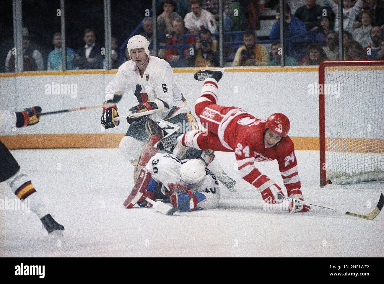 Soviet forward Sergei Makarov, right, leaps over West German goalie ...