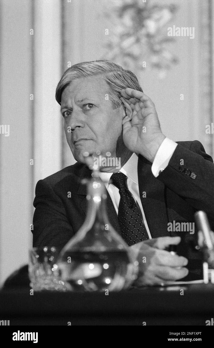 West German Chancellor Helmut Schmidt cups his ear to listen to ...