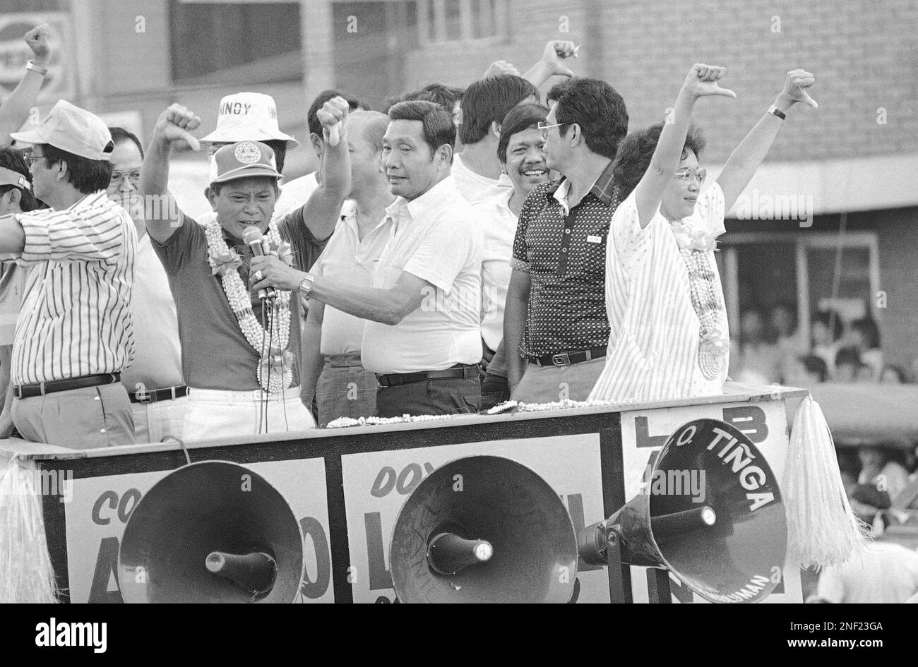 Corazon “Cory” Aquino, right, shows thumbs-down signs to thousands of ...