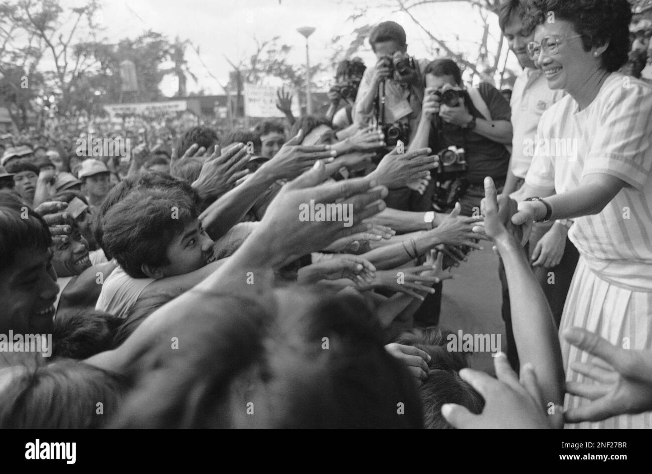 An enthusiastic crowd reaches out to shake the hand of opposition ...