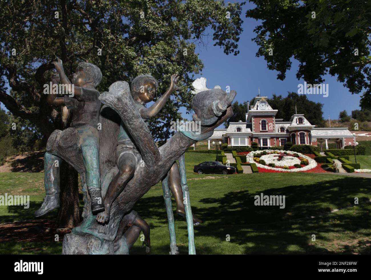 A bronze statue of children playing in a tree is seen on the grounds in ...