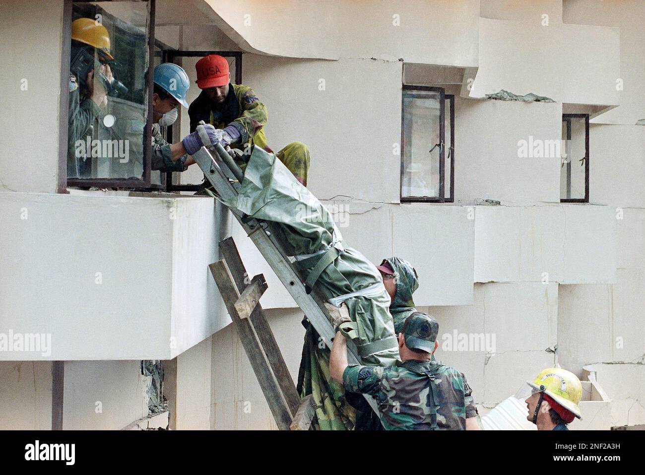 American rescue workers lower the covered body of Richard Finley, a ...