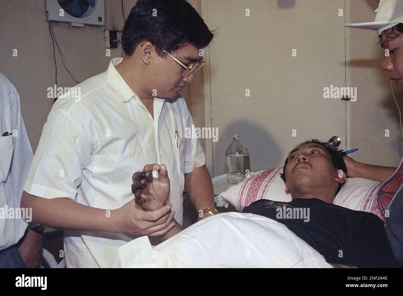 A doctor examines Arnel Calabia where he was rushed to a Manila ...