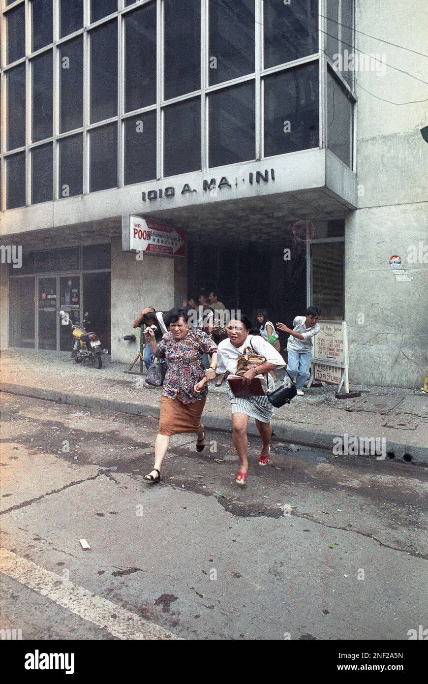 Panic-stricken workers flee a building in Manila as an earthquake ...