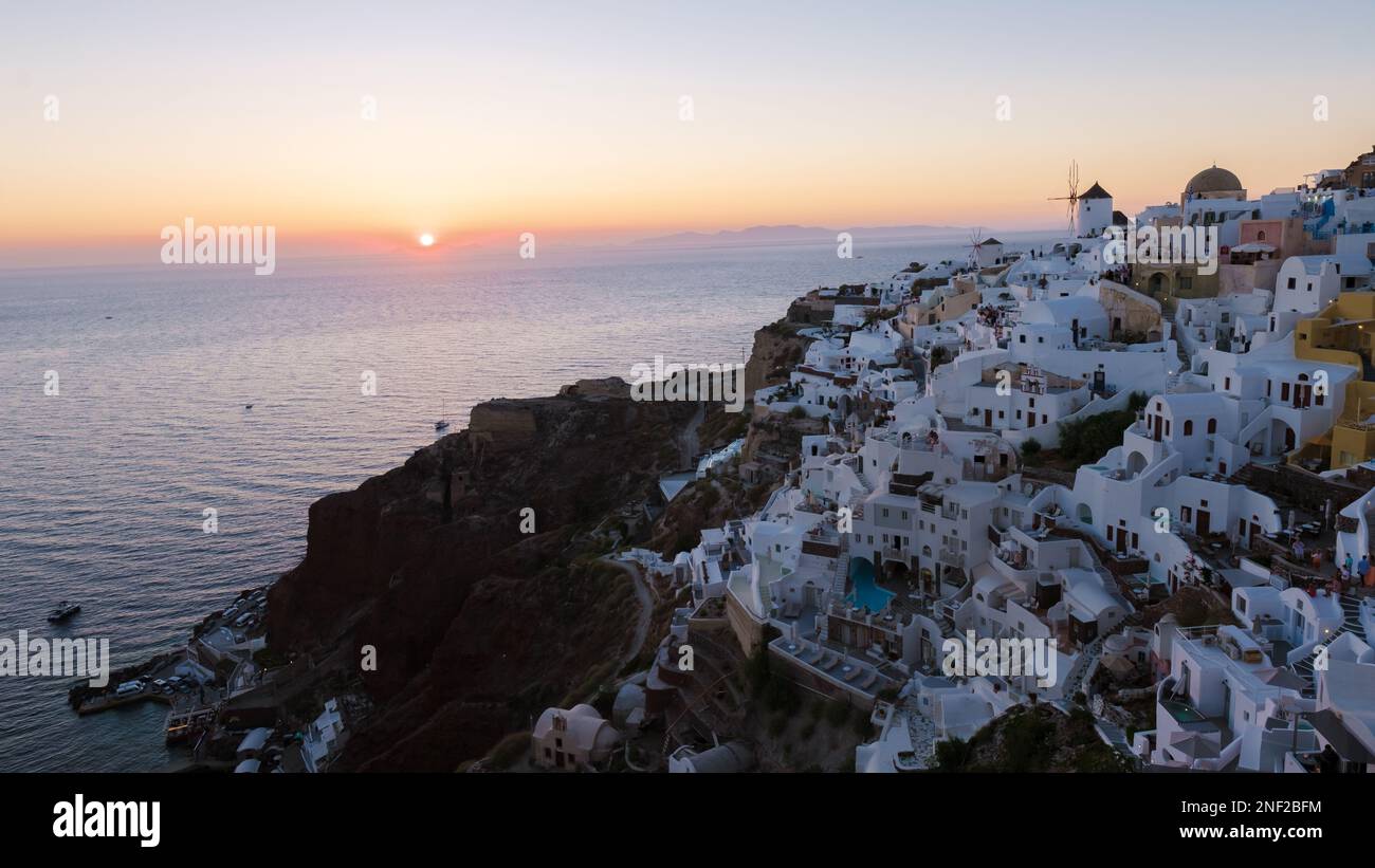 sunset by the ocean of Oia Santorini Greece, a traditional Greek ...