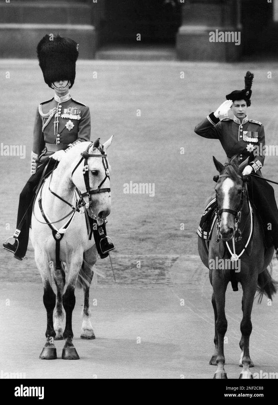 Queen Elizabeth II sitting sidesaddle on her mount, takes the salute of ...