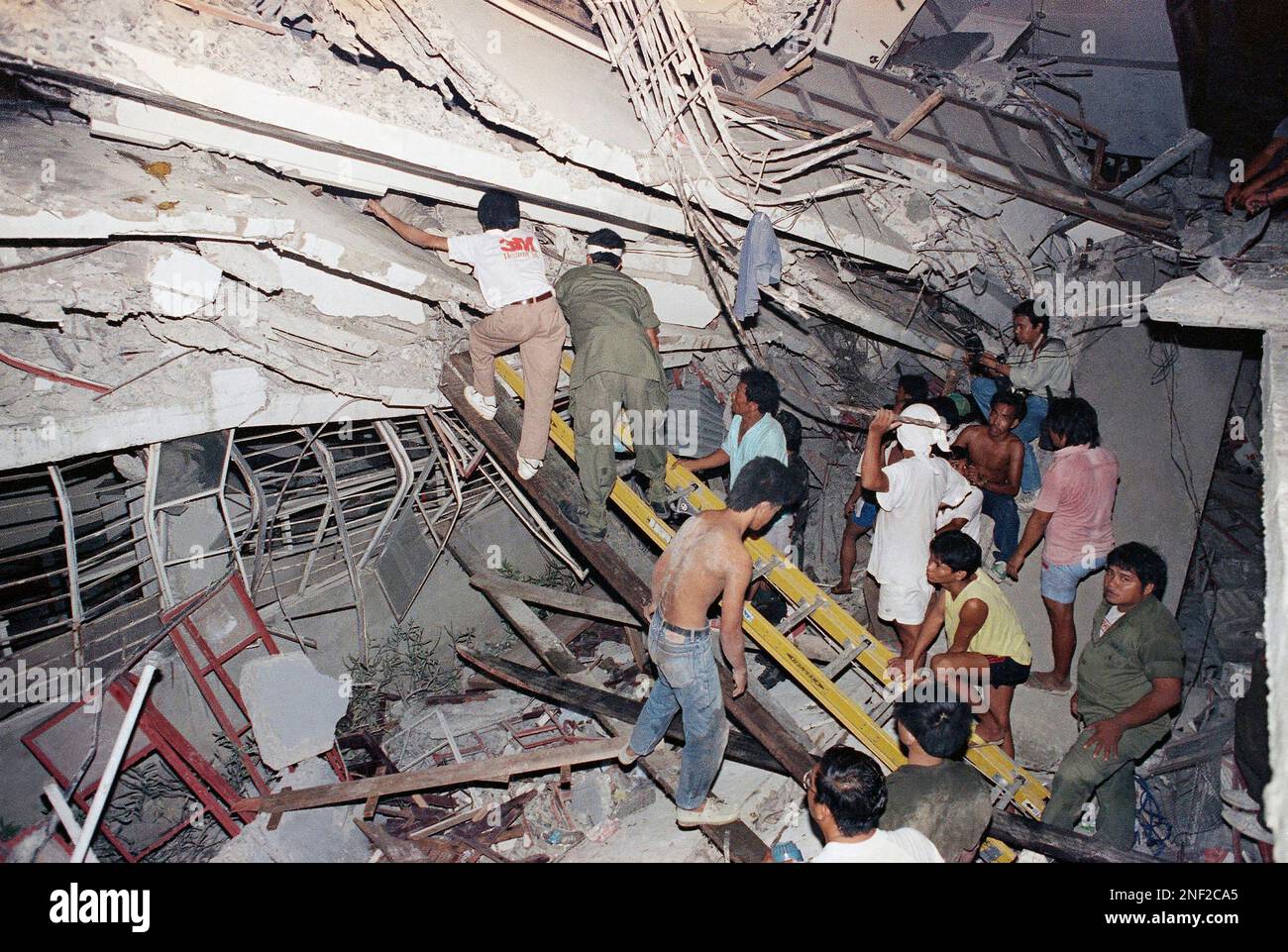 Rescue workers sifting through the rubble of the six-story Christian ...